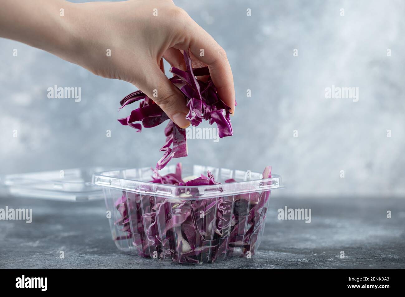 Female hand taking chopped cabbage from plastic container Stock Photo ...