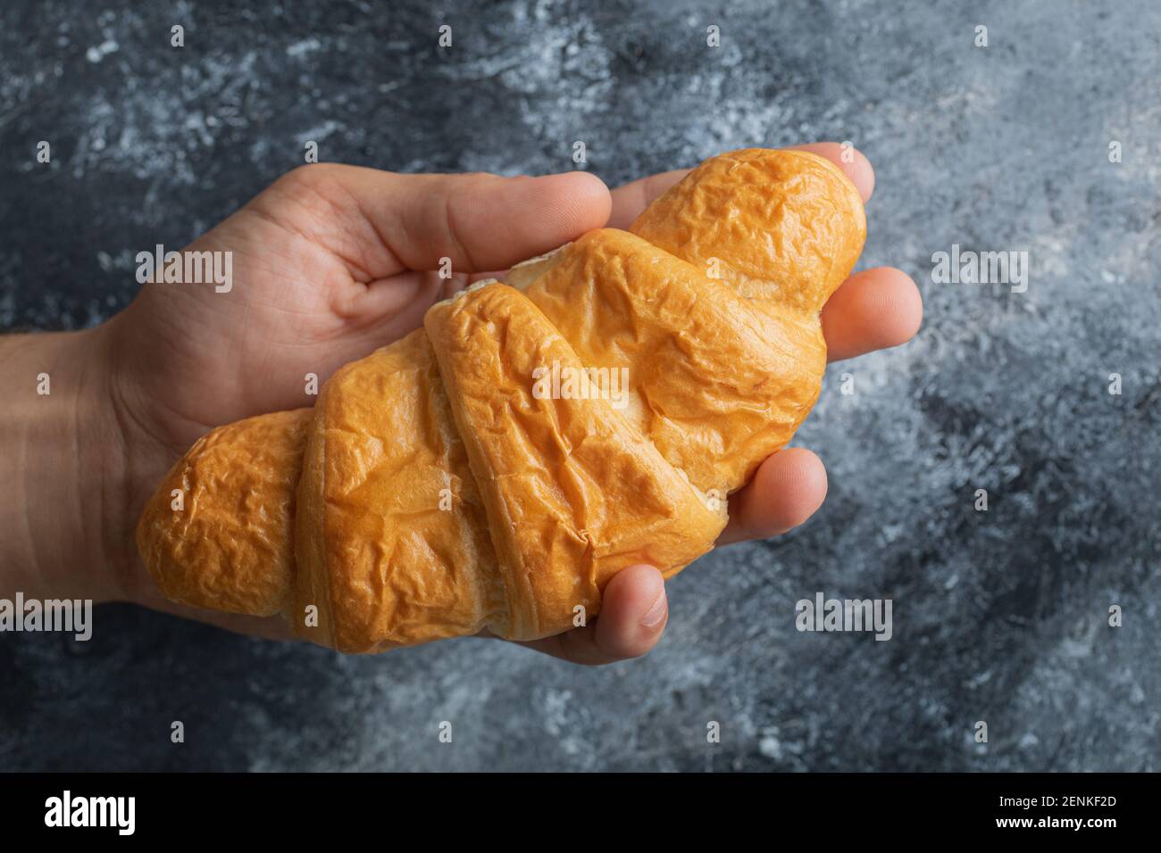Male hands holding fresh croissant on marble background Stock Photo - Alamy