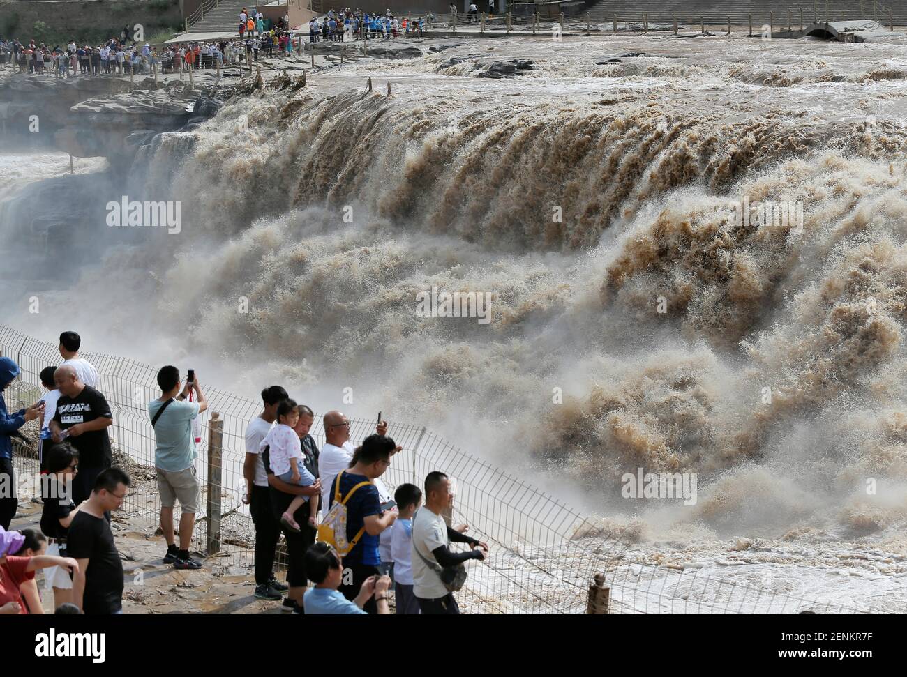 Tourists view the Hukou Waterfall on the Yellow River, also known as ...