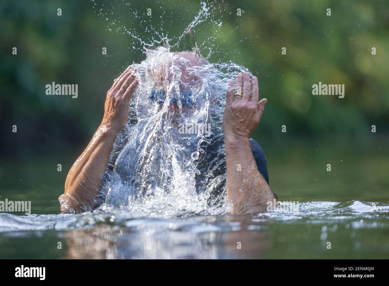 Swimmer in river, splashing water on face Stock Photo - Alamy
