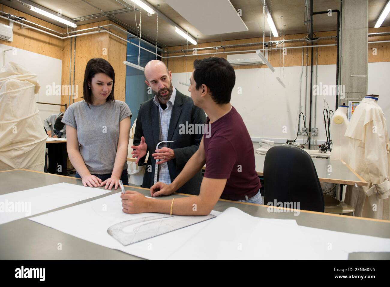 Lecturer talking to fashion students Stock Photo - Alamy