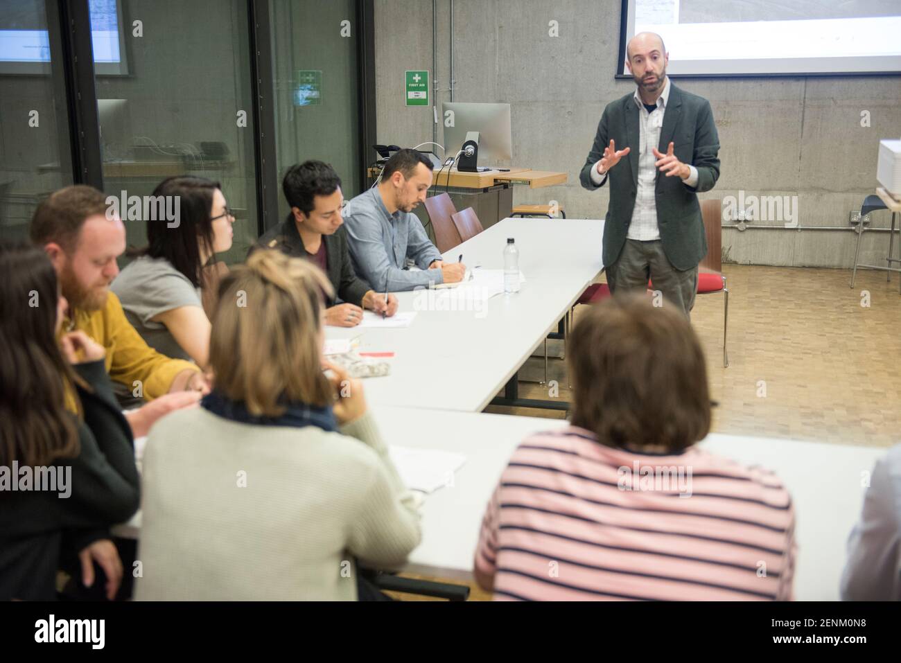 Lecturer giving lecture to group of students Stock Photo - Alamy