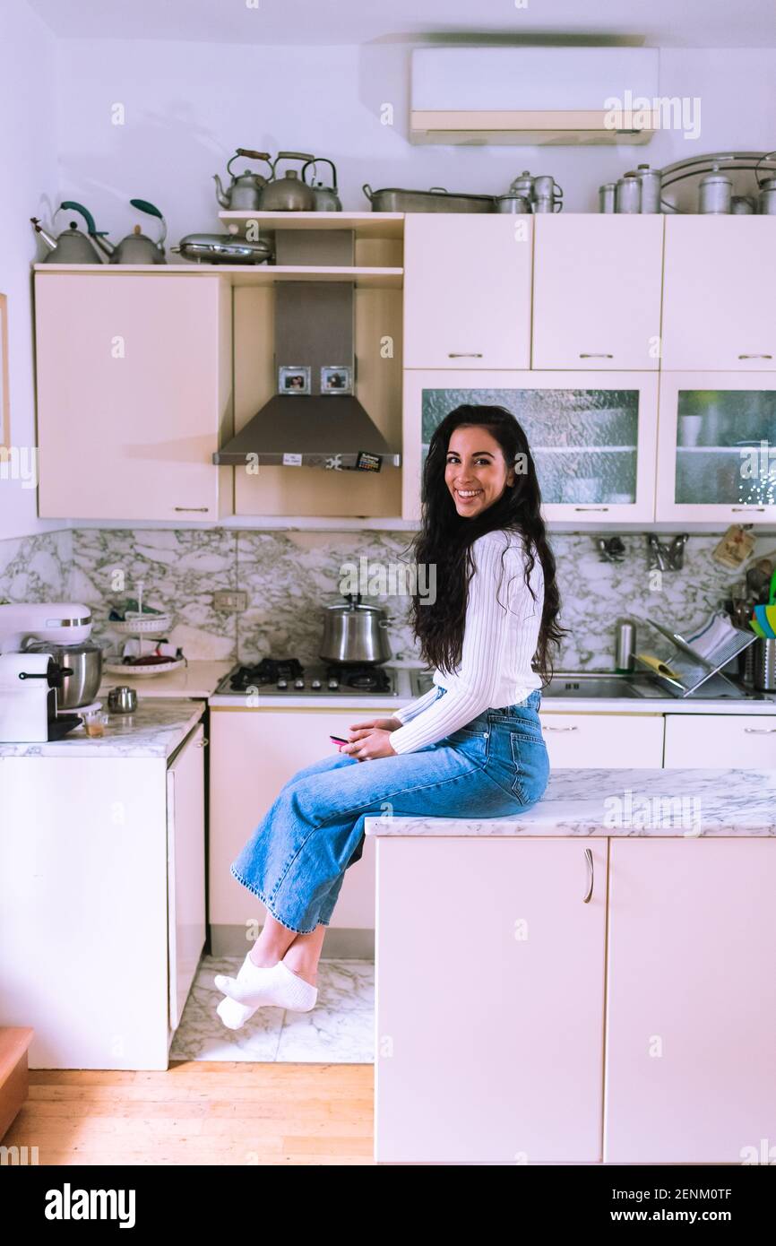 Woman sitting on kitchen counter hi-res stock photography and images ...