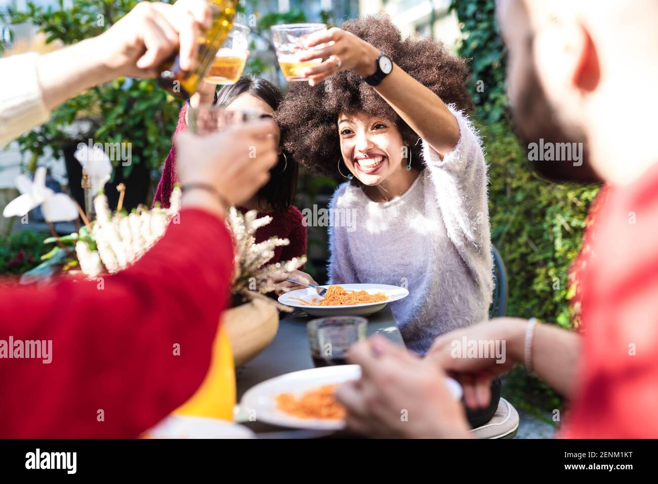 Friends eating meal together outdoors, raising a Stock Photo - Alamy