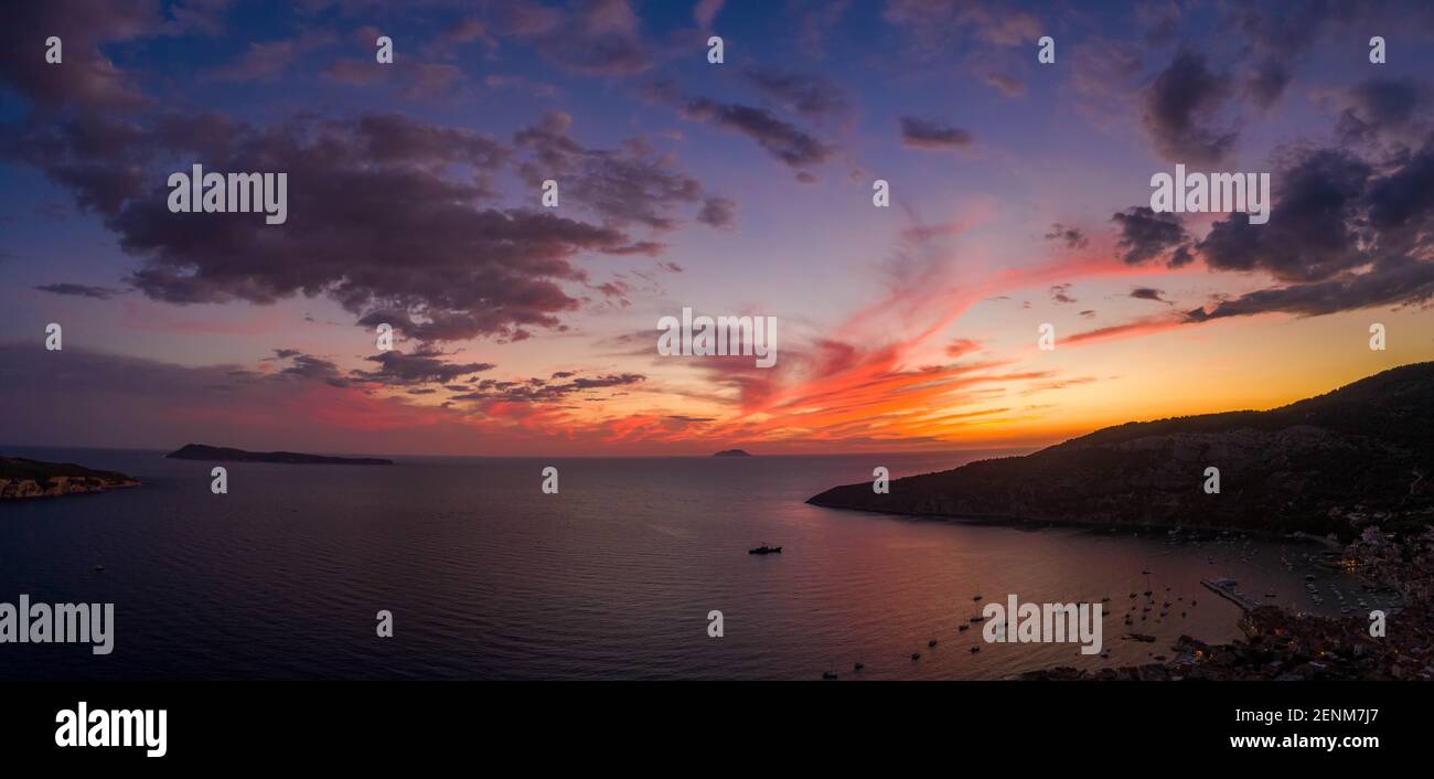 Aerial panorama drone shot of sunset burning sky clouds on Komiza town ...