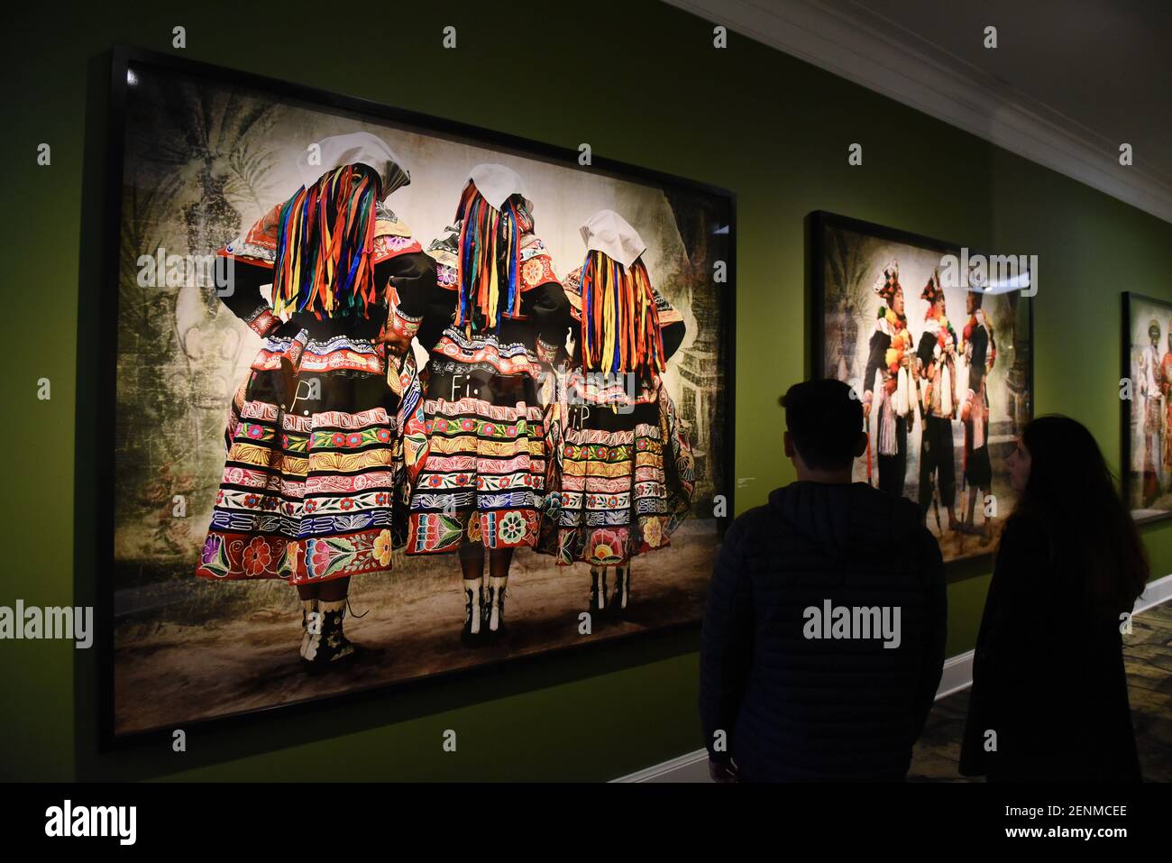 People look at the paintings during the exhibition in Lima. Mario ...