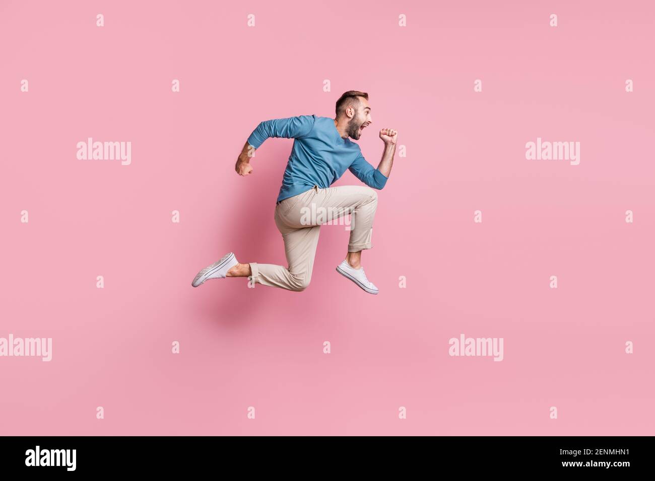 Full length photo of cute hurry young guy wear blue pullover jumping ...
