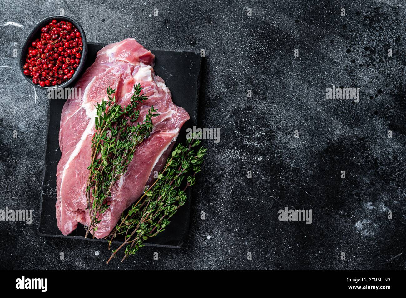 Raw pork shoulder meat cut on a marble board. Black background. Top ...