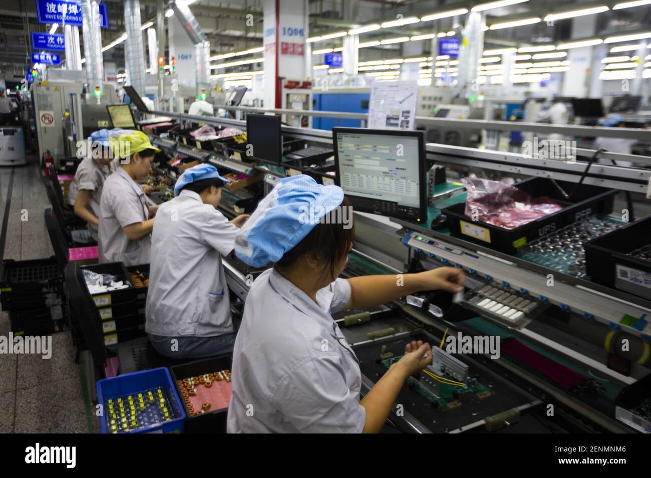 Chinese workers assemble batteries for electric vehicles at the plant ...