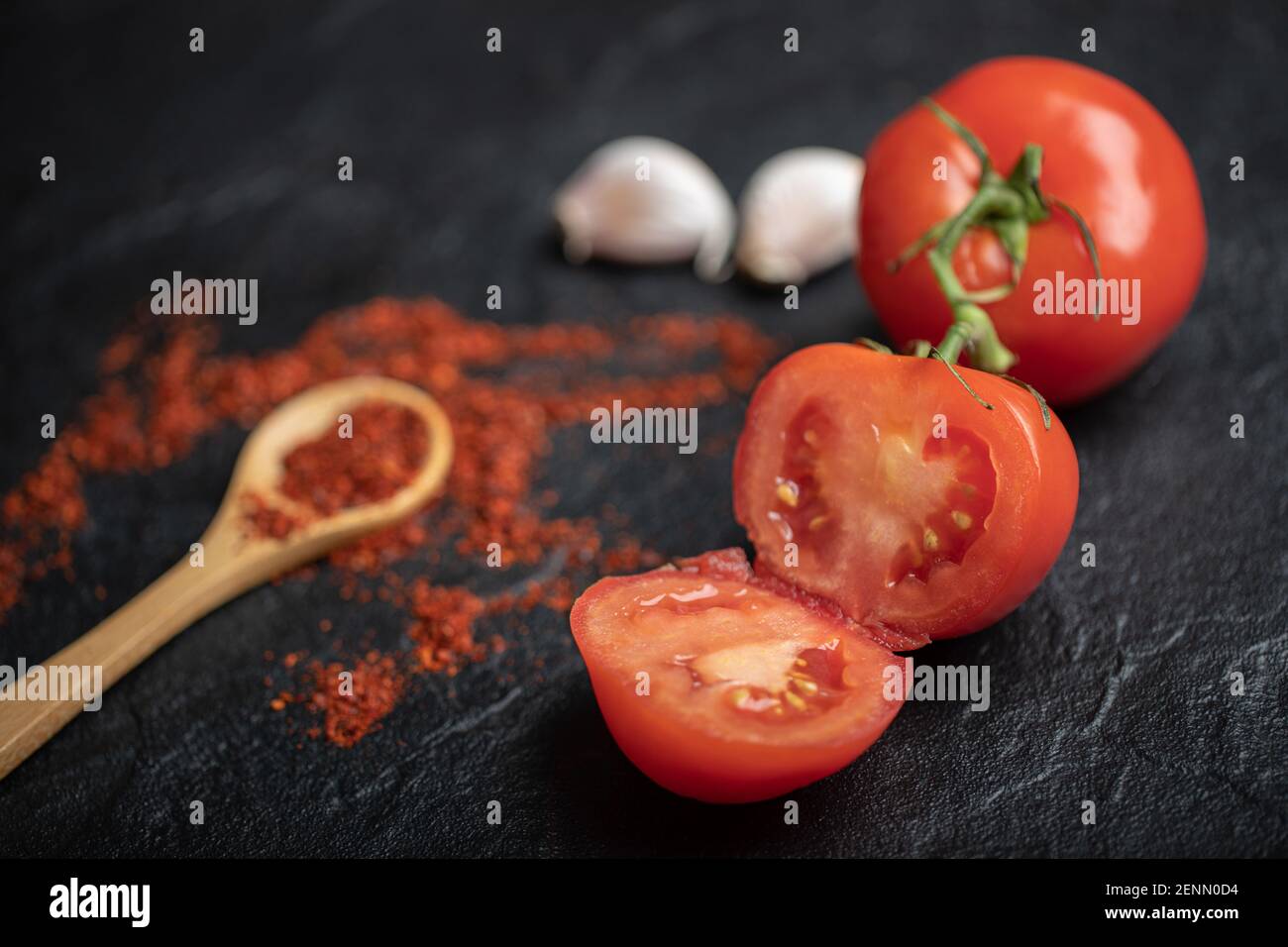 Close up photo of ripe tomatoes whole or half cut with garlic and red ...