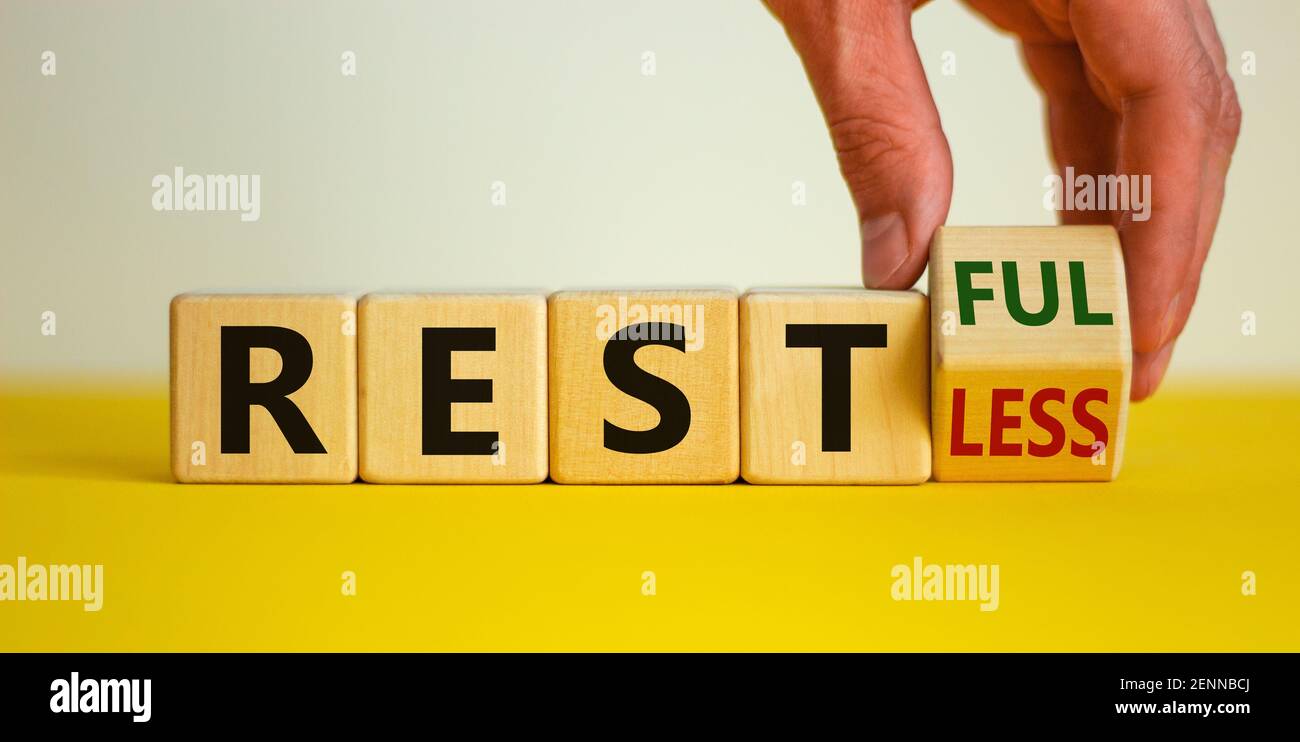 Restless or restful symbol. Businessman turns the wooden cube, changes ...