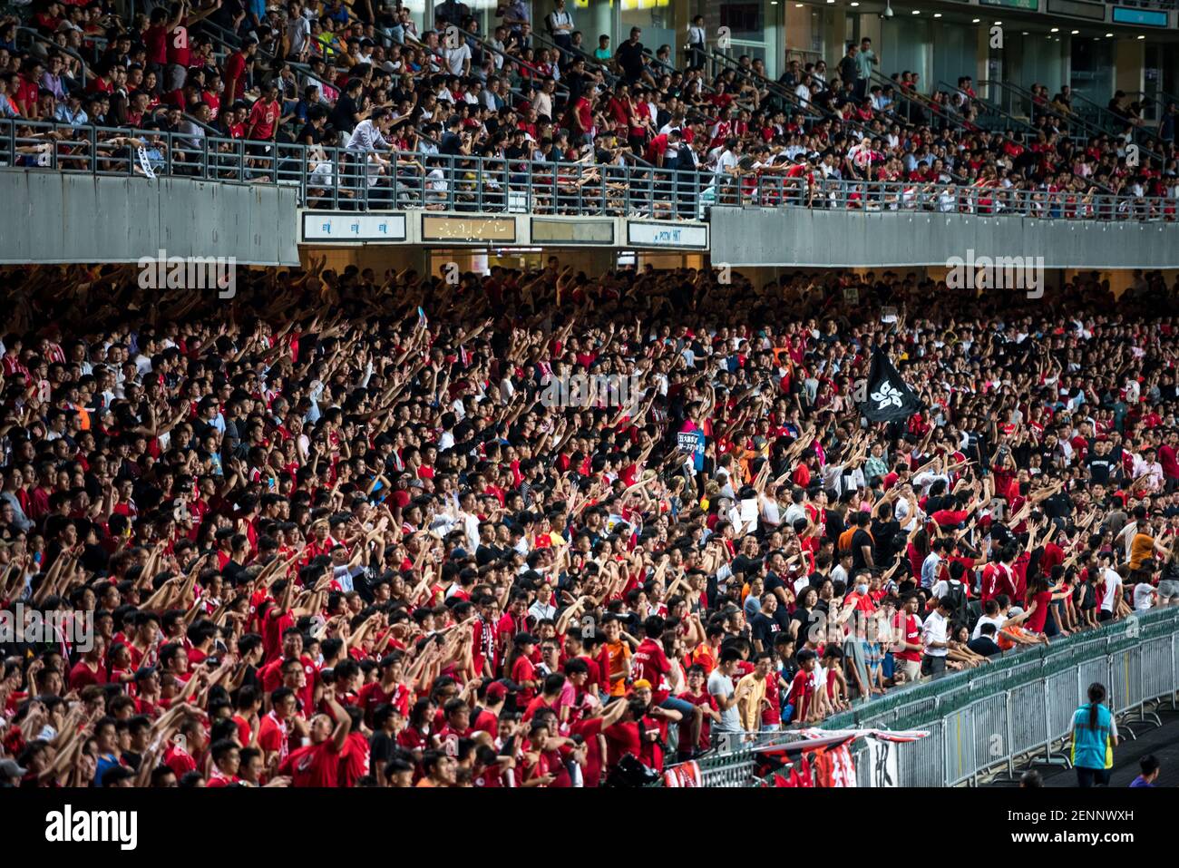 Hong Kong fans, clad in red, cheering on their home team during the ...