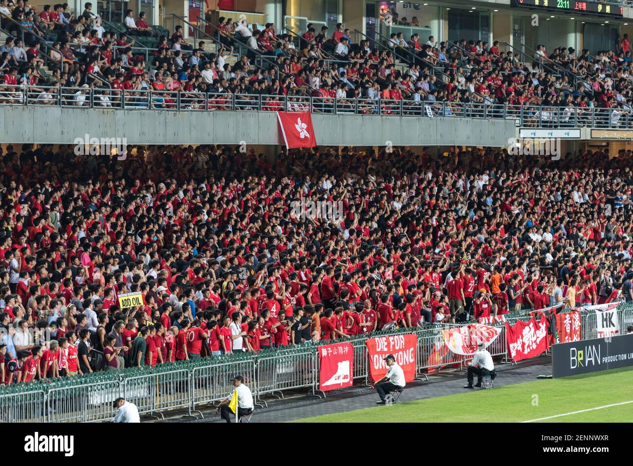 Hong Kong fans, clad in red, cheering on their home team during the ...