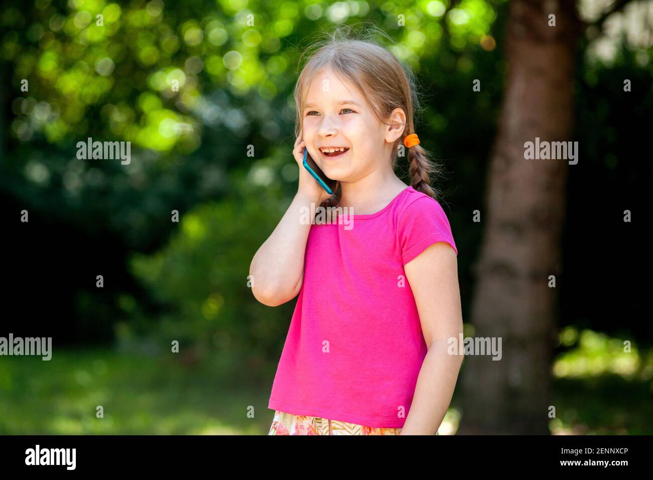 Happy cheerful little girl, child talking on phone laughing, young kid ...