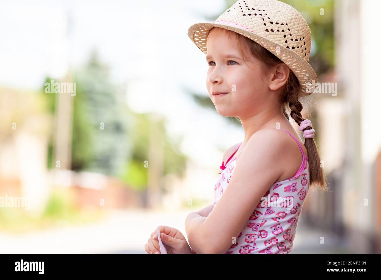 One happy cheerful joyful little girl alone, lone child in a sun hat ...