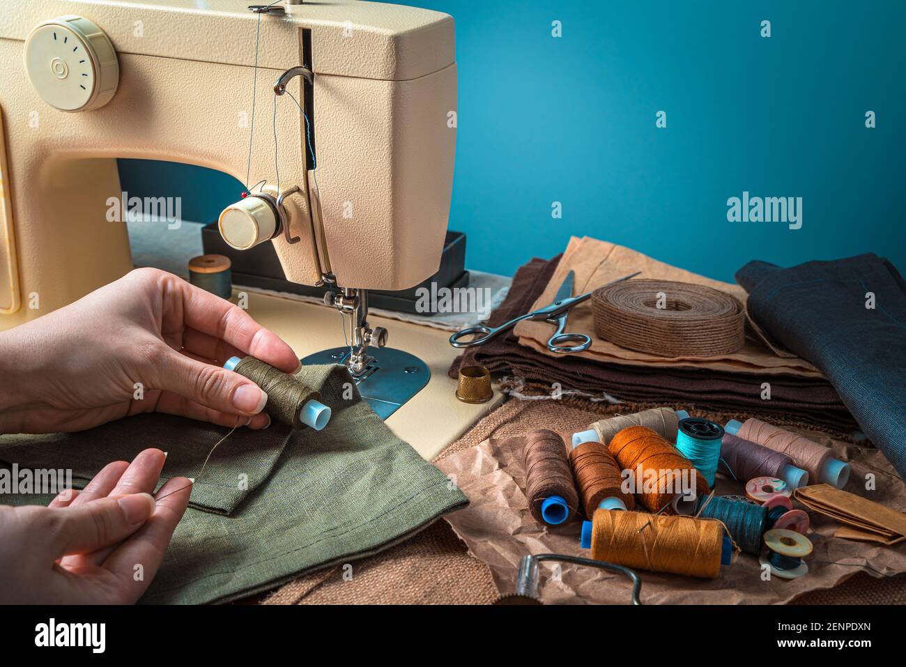 A woman dressmaker picks up threads on the background of a sewing ...