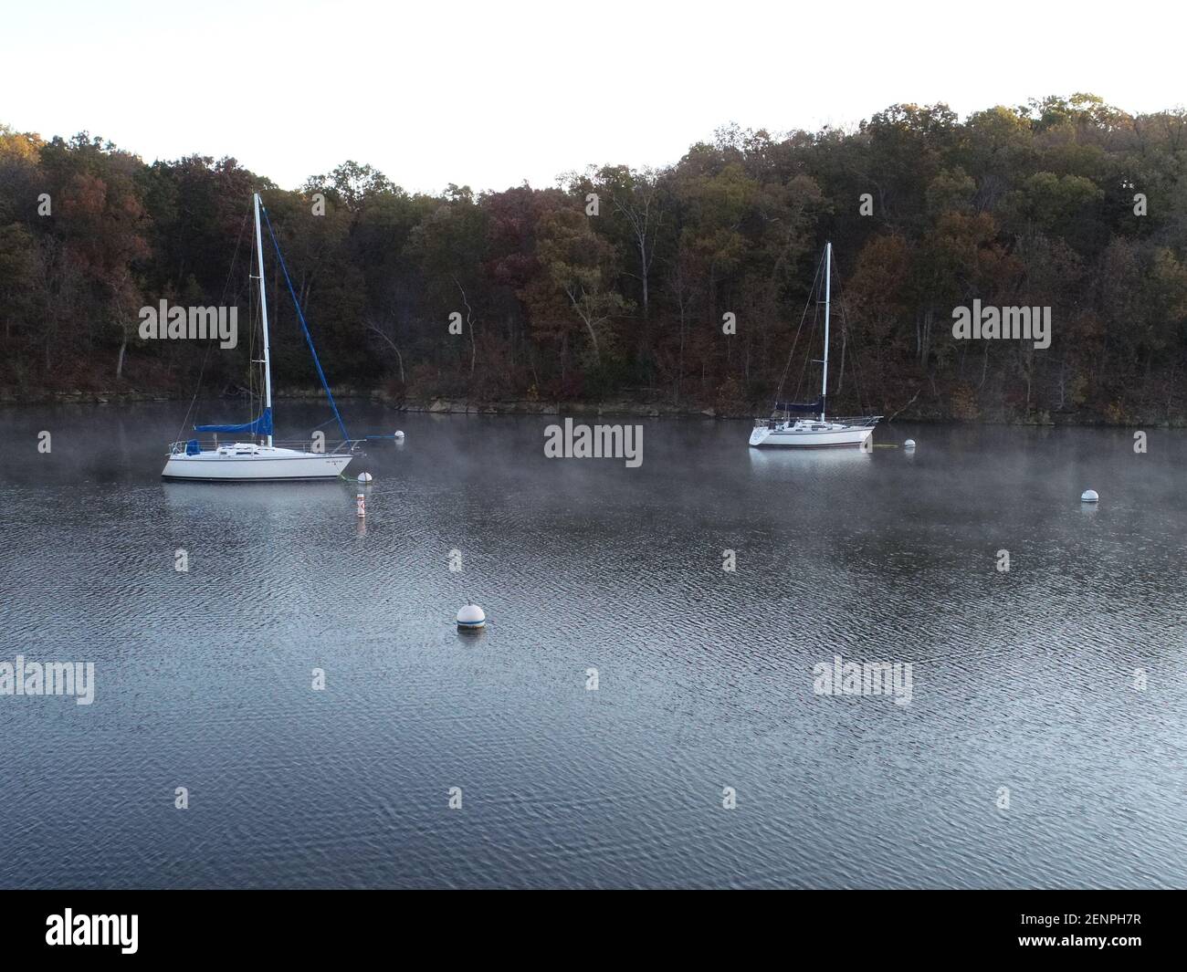 Fog rolls across a lake past stationary sailboats Stock Photo - Alamy