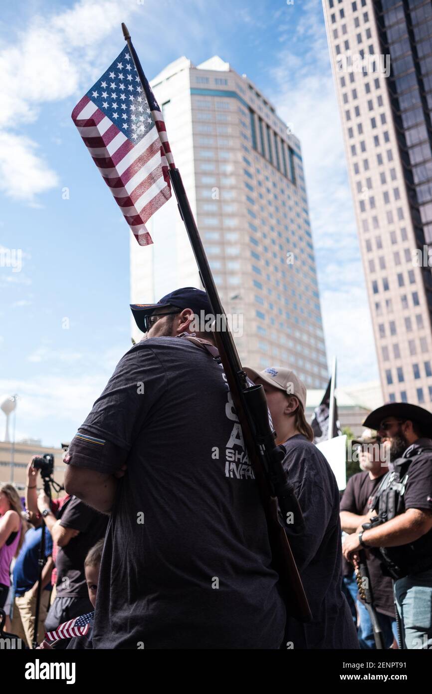 An activist holds their gun with a flag in the barrel during a pro-gun ...
