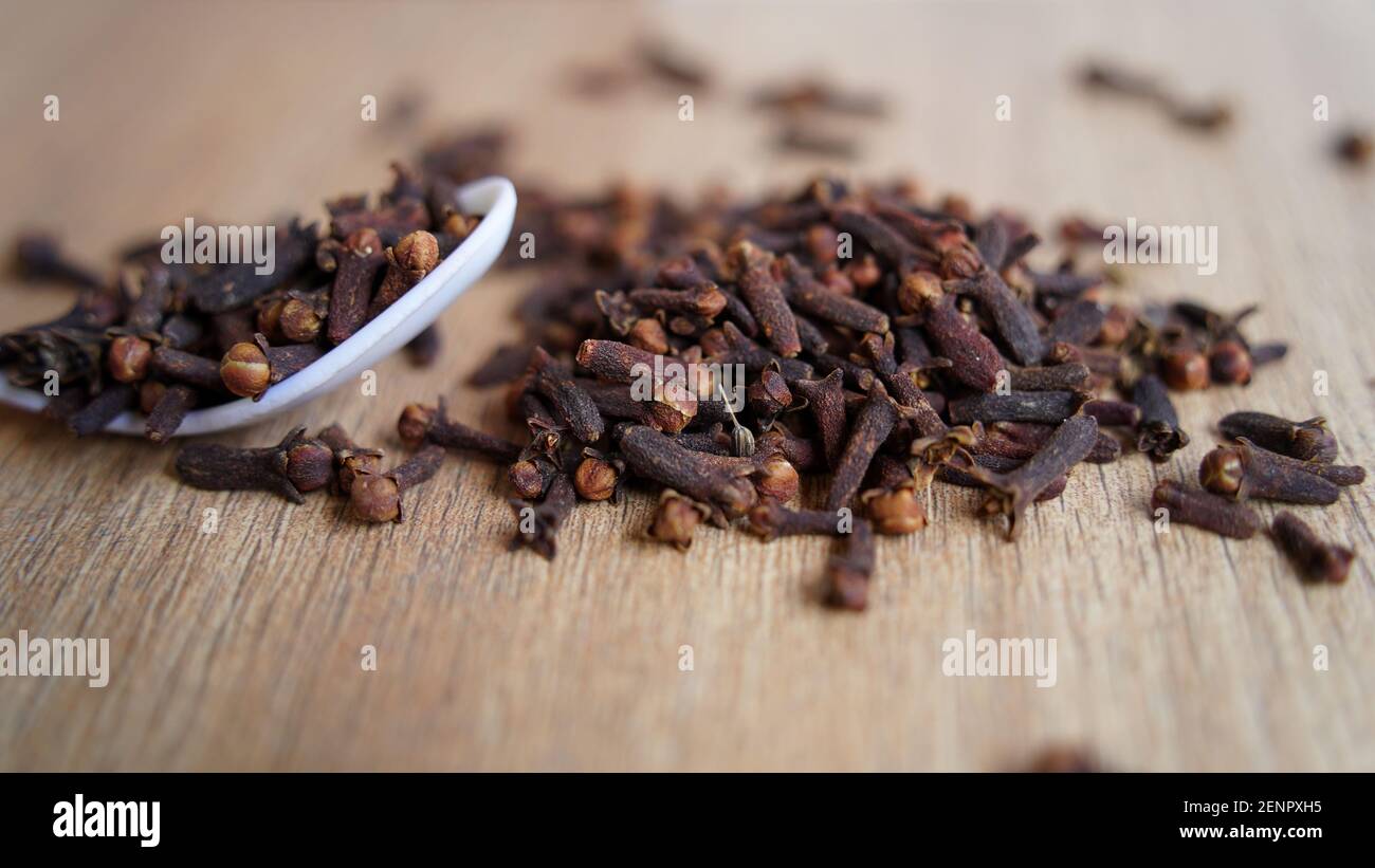 Indian dried clove spice on wooden table background. Dry aromatic ...