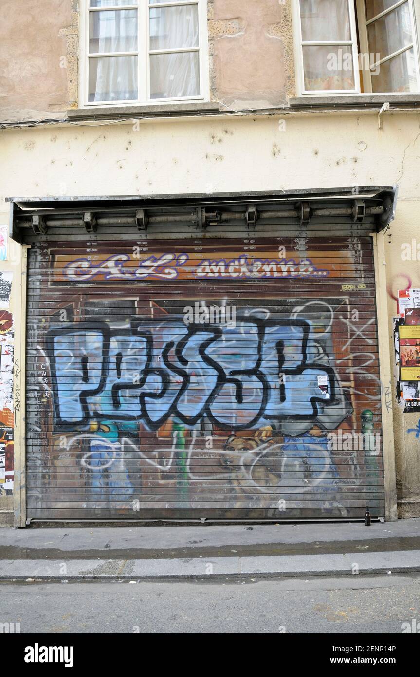 Shop door covered with grafitti with windows Stock Photo - Alamy