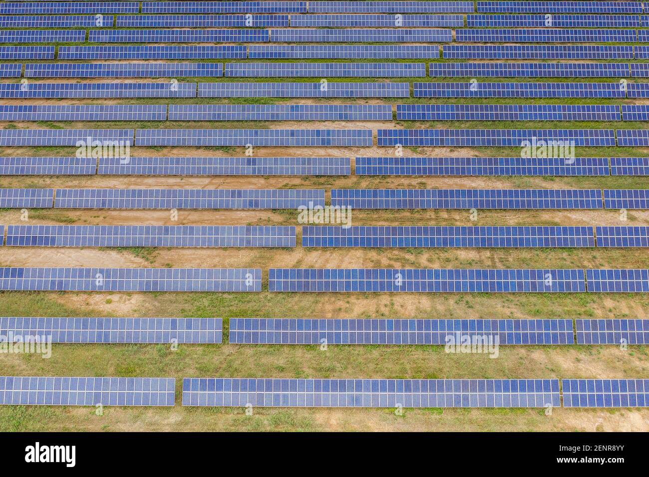 An aerial view of arrays of solar panels at a photovoltaic power plant ...