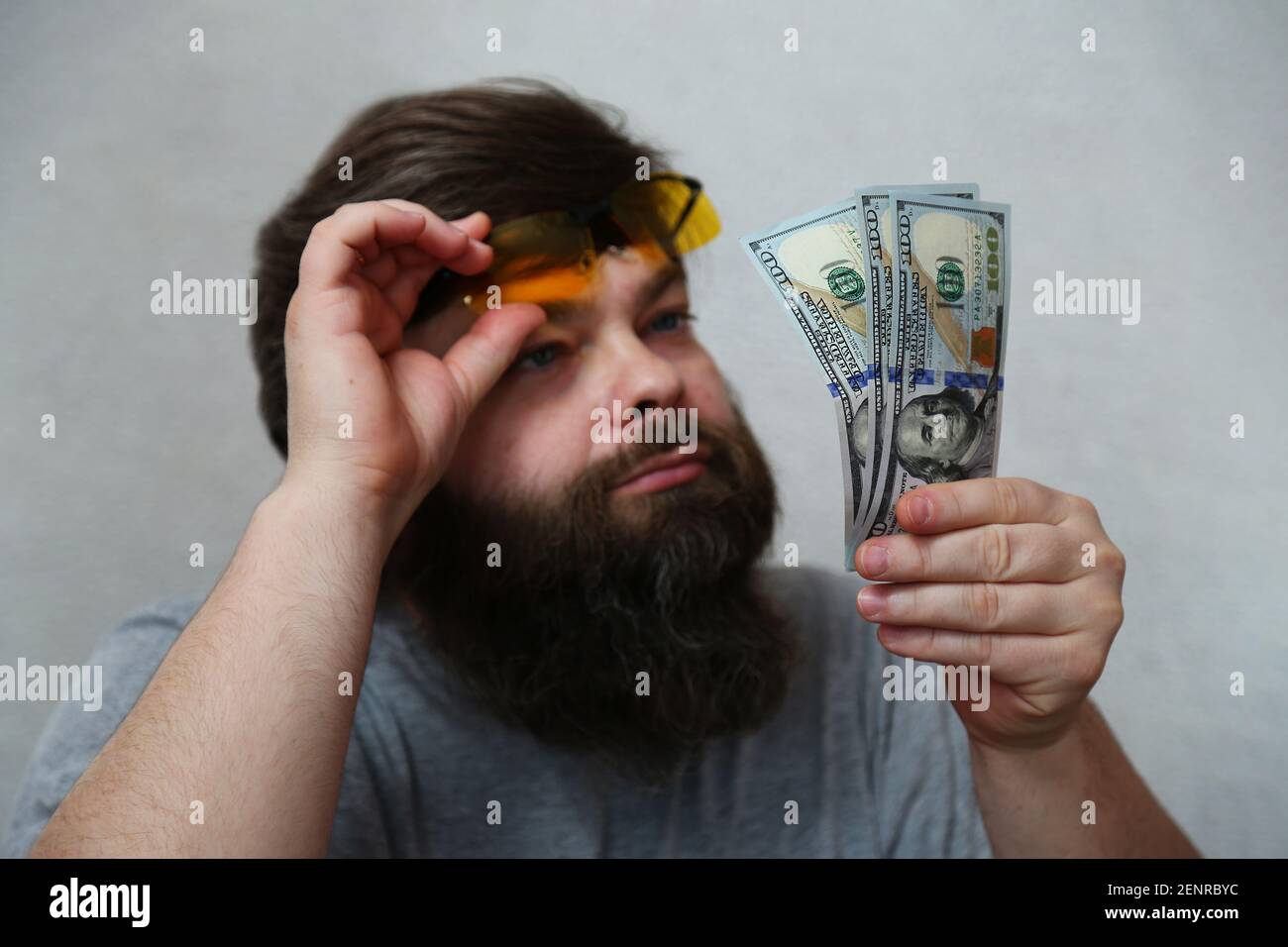 A man with a long beard is holding cash in his hand. An overgrown ...