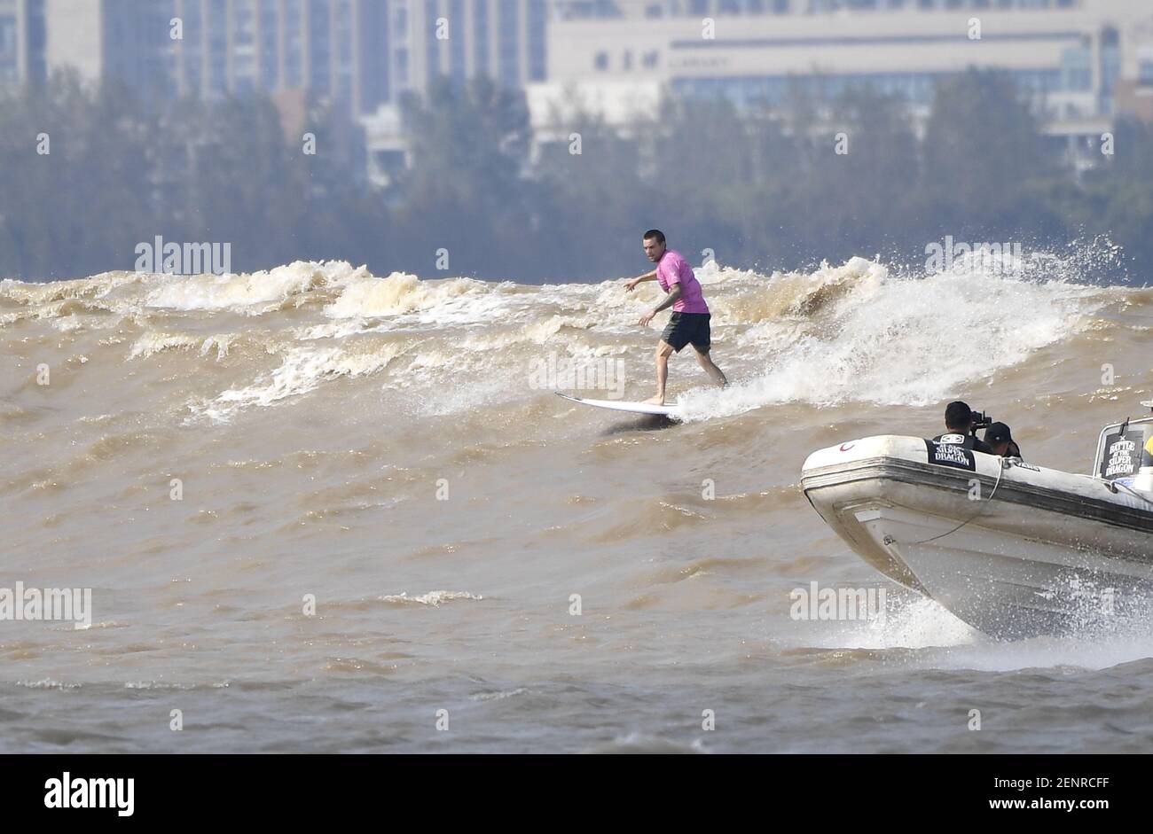 A surfer rides a wave on the Qiantang River in Hangzhou city, east ...