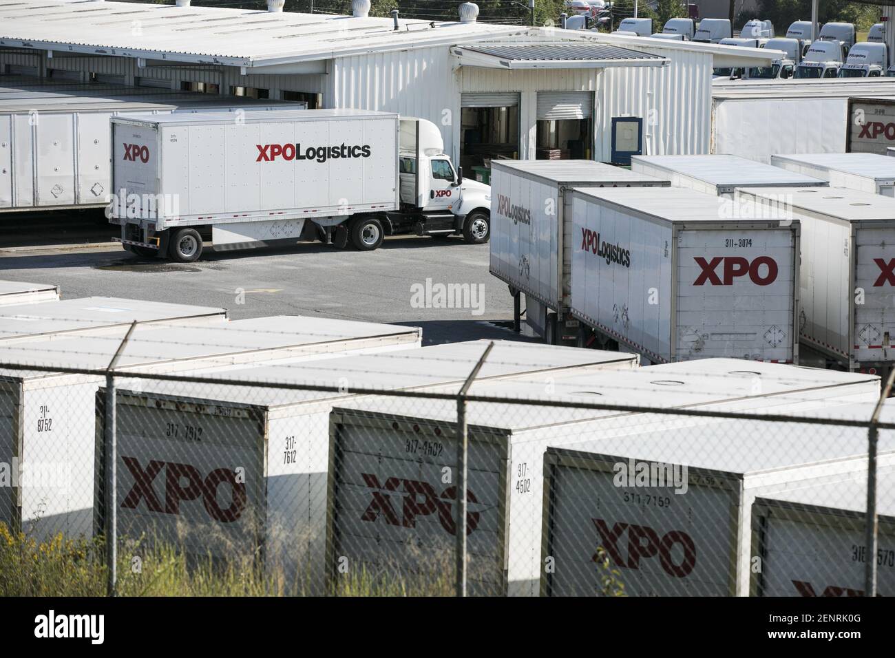 XPO Logistics semi-trailer trucks and trailers at a freight facility in ...