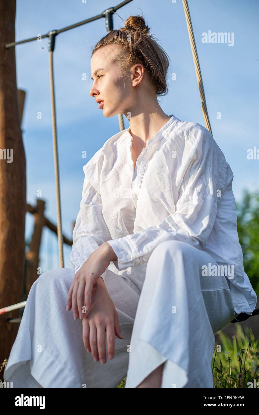 European woman with blonde hair outside pulled back into a tight bob ...