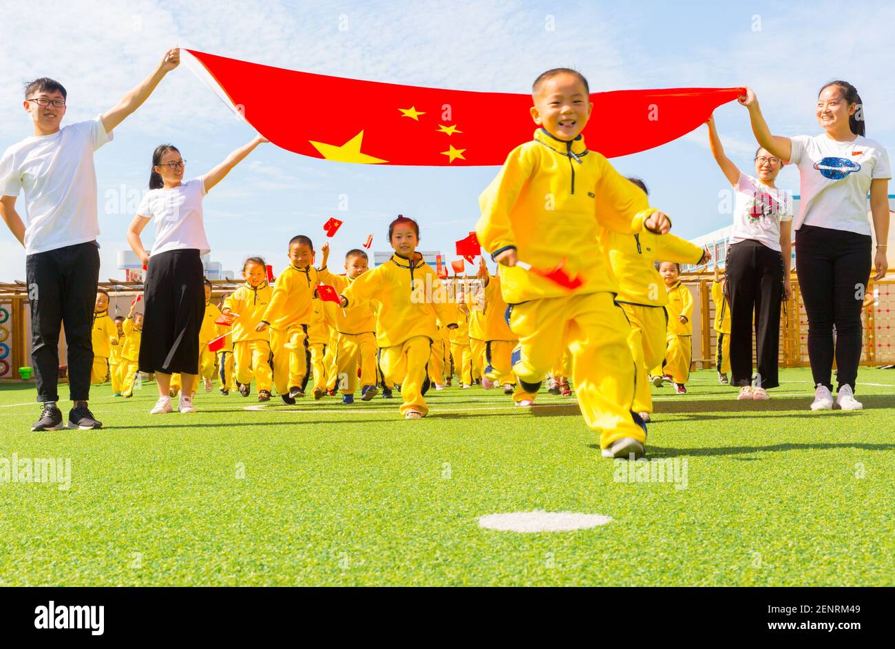 Kindergarten kids do group red fan dance to embrace the upcoming of the ...