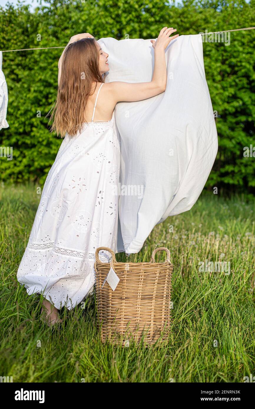White girl model with basket outside hanging washed laundry Stock Photo ...