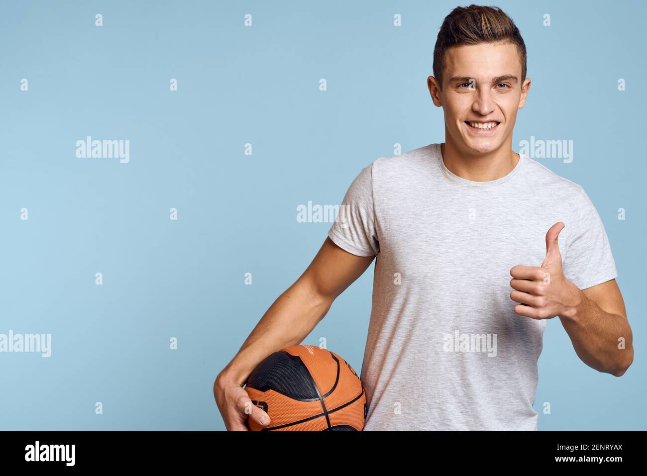 Sporty man playing ball workout lifestyle studio blue background Stock ...