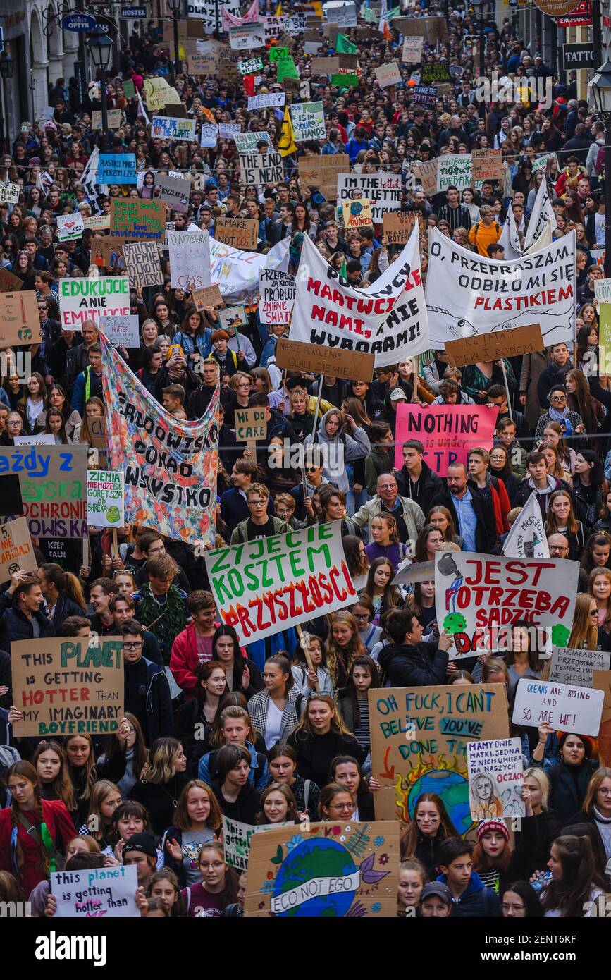 Students, parents and activists march while holding banners and ...