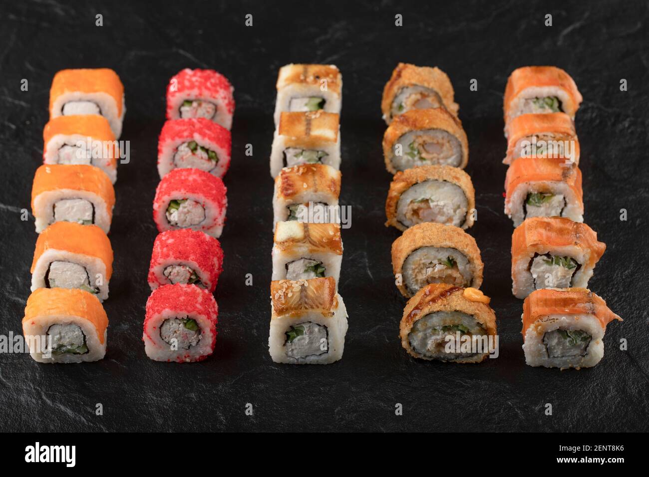 Set of delicious traditional sushi rolls on black surface Stock Photo ...