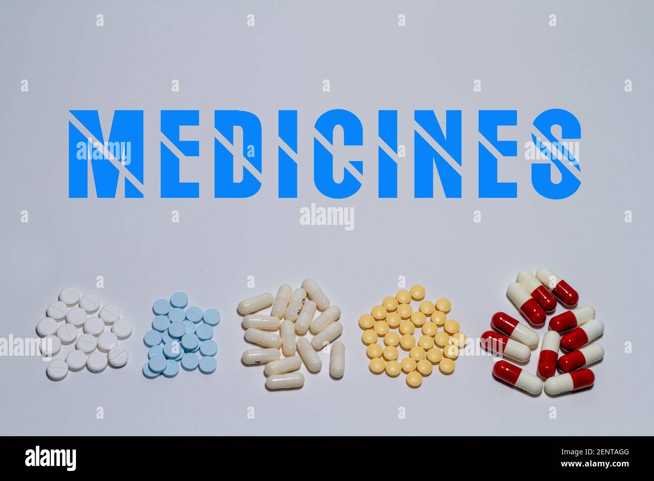 Medicine concept. Pills and capsules arranged by groups of blue, yellow ...