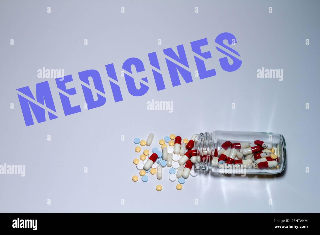 Medicine concept. Pills and capsules come out of a transparent glass ...