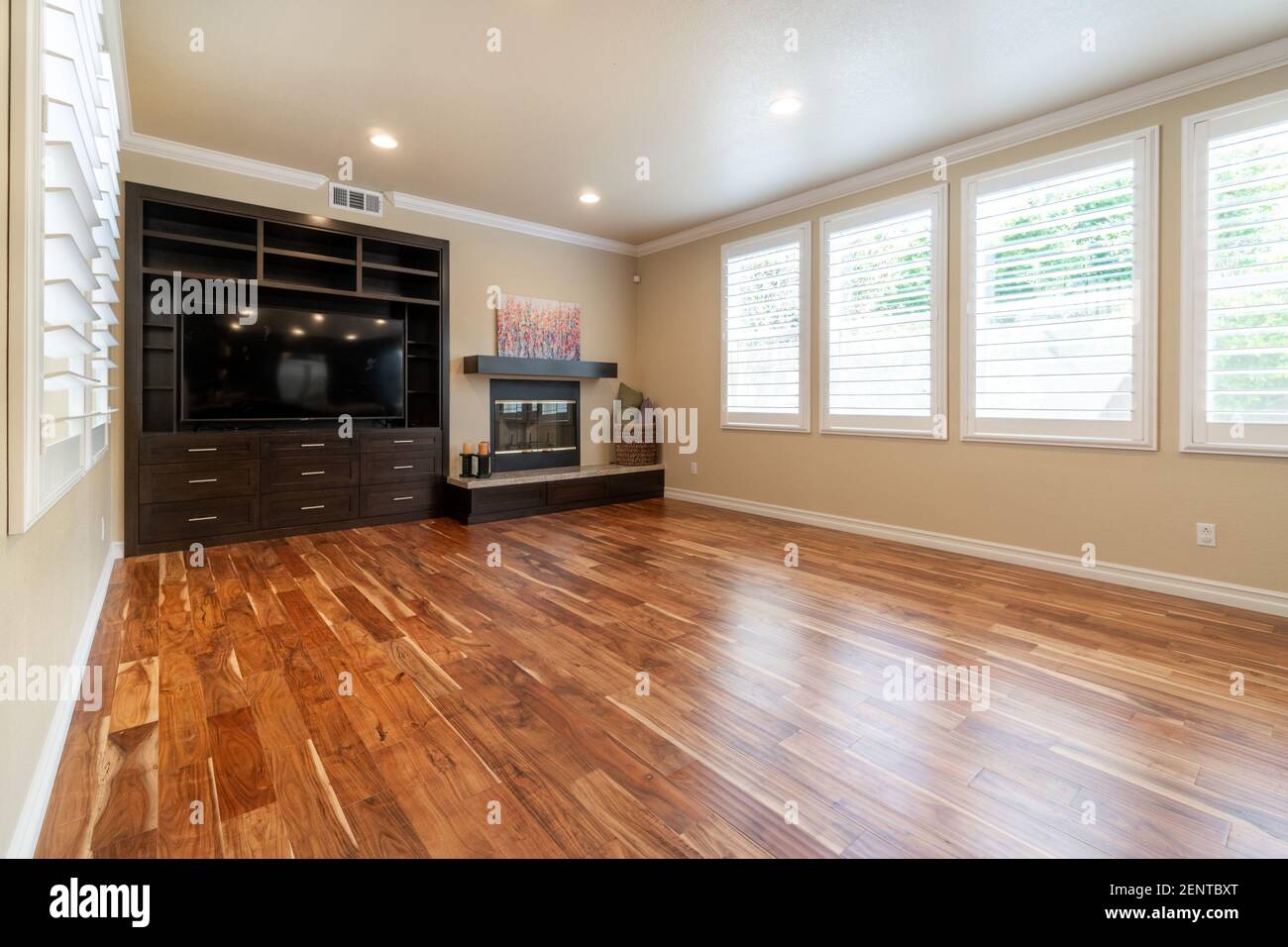 Bright beige large empty room with wood floor, molding and windows. Modern bright room ...