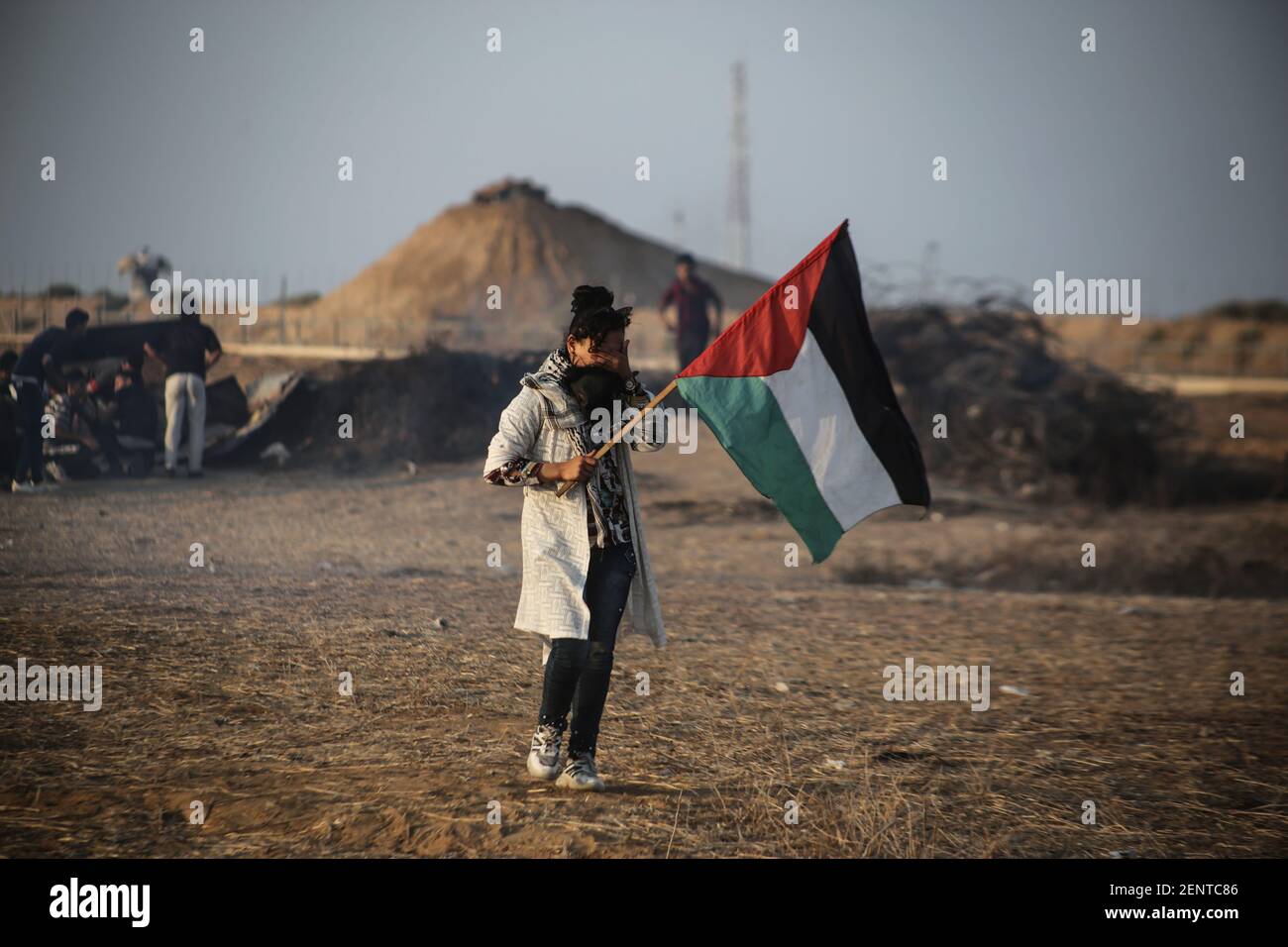 A Palestinian demonstrator holding a Palestinian flag walks along the ...