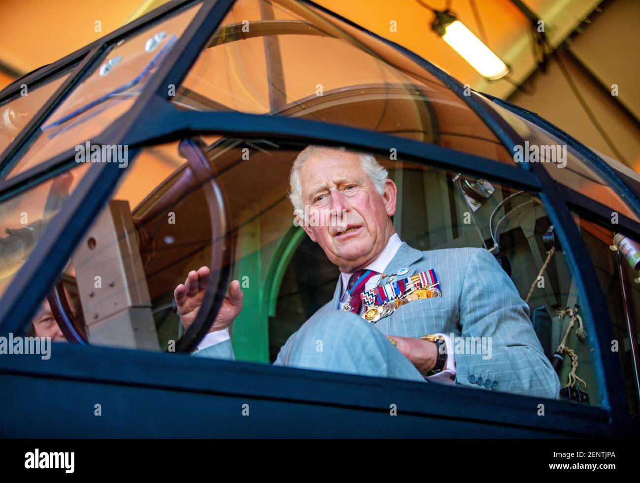 Prince Charles sits in the cockpit of a replication slider and poses ...