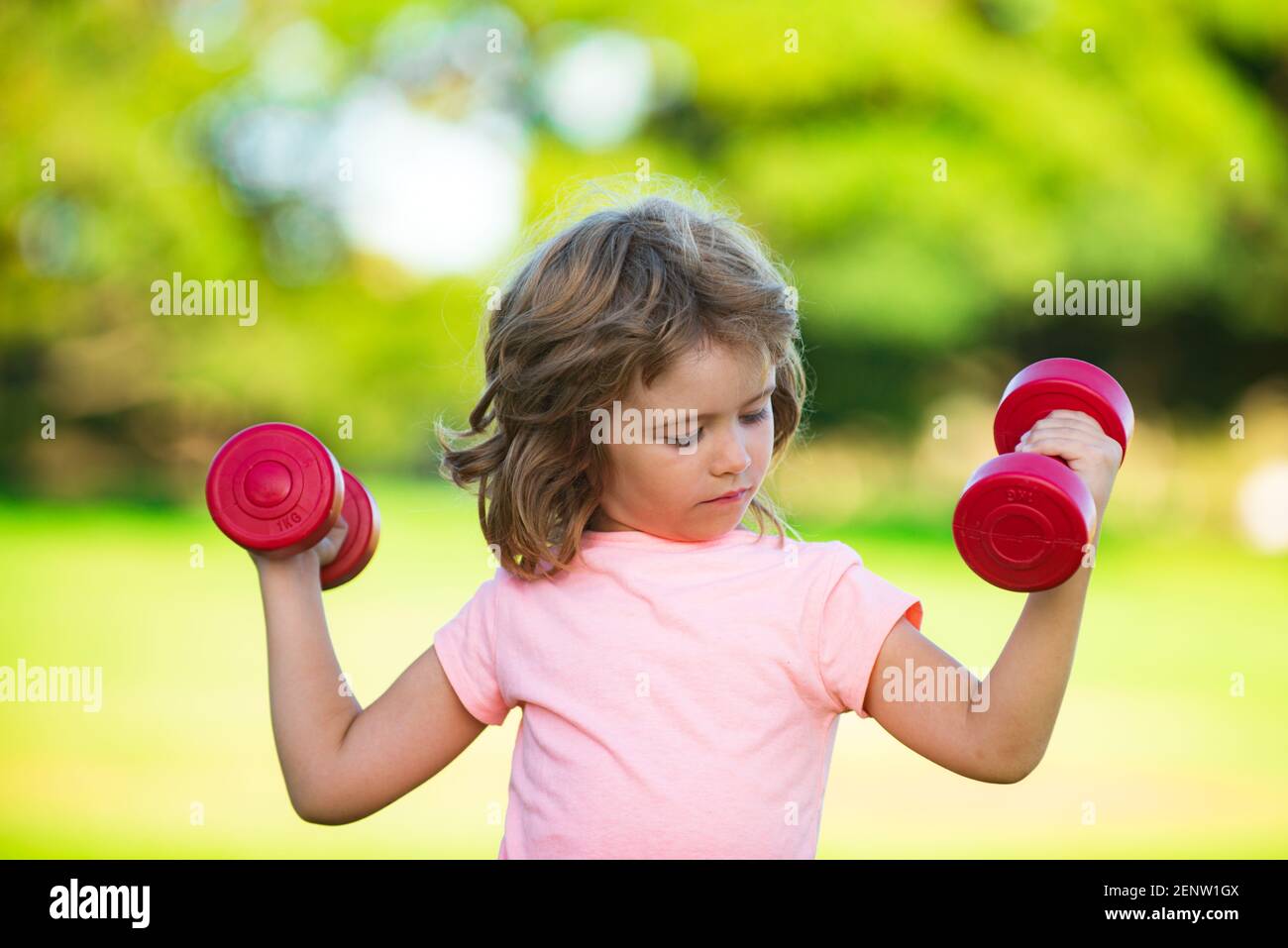Kid exercising in park. Active boy, healthy lifestyle. Sport child with strong biceps muscles ...