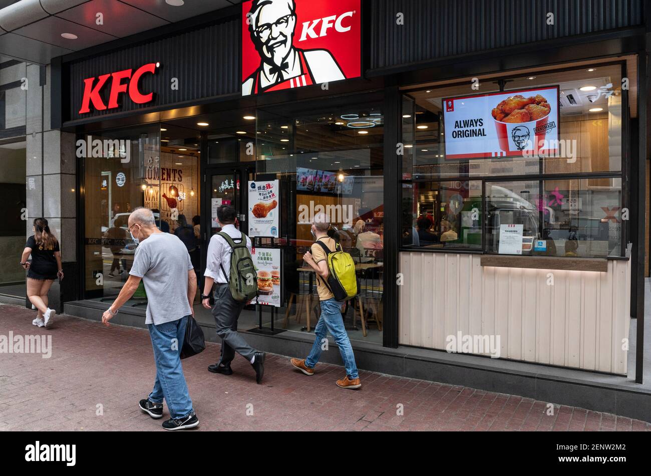 Pedestrians walk past an American fast food chicken restaurant chain ...