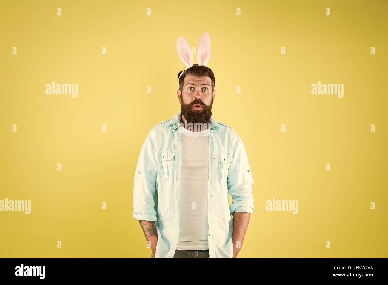 Easter surprise. Surprised rabbit yellow background. Bearded man open ...