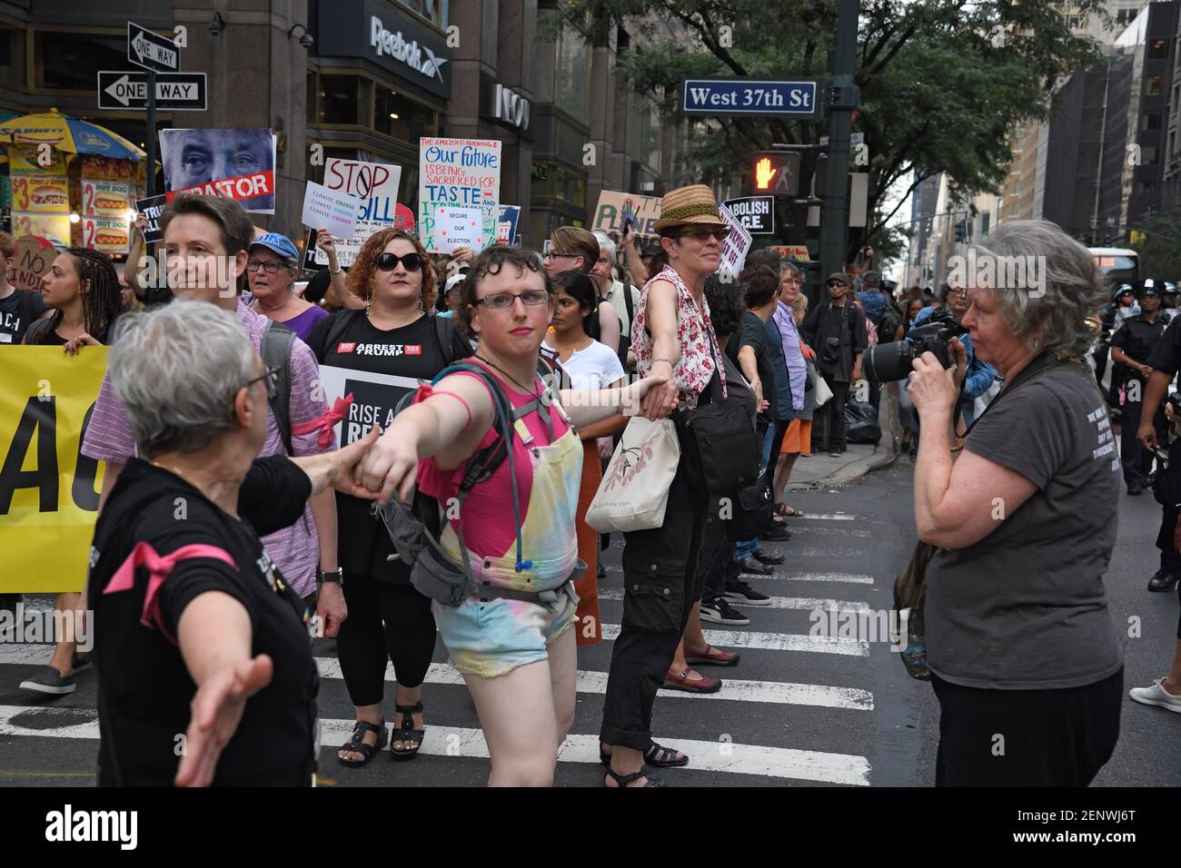 Protesters hold hands forming a chain during the Rise and Resist ...