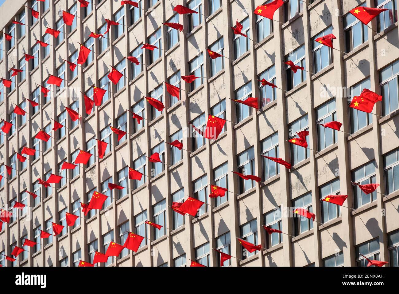 Chinese national flags flutter on the windows at the campus of Liaoning ...
