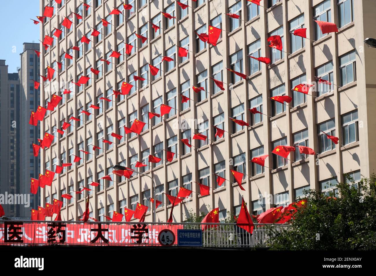Chinese national flags flutter on the windows at the campus of Liaoning ...