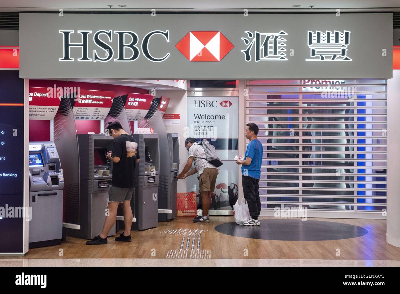 Commuters withdraw money from British multinational banking HSBC ATM machines in Hong Kong ...