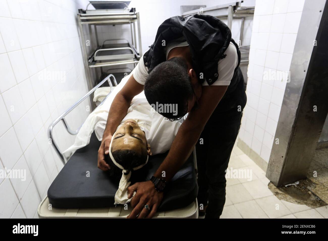 Palestinian relatives mourn on the body of Saher Othman, 20, in the ...