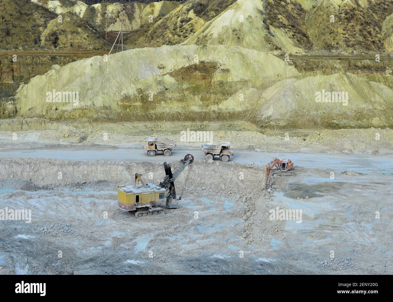Aerial top view of mining industry. Excavator in quarry loads rock into ...