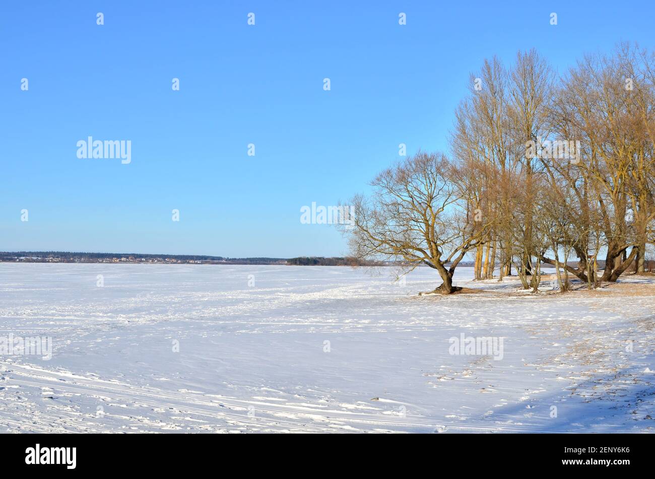 Winter scene of frozen lake on blue sky background. Snowy river view ...