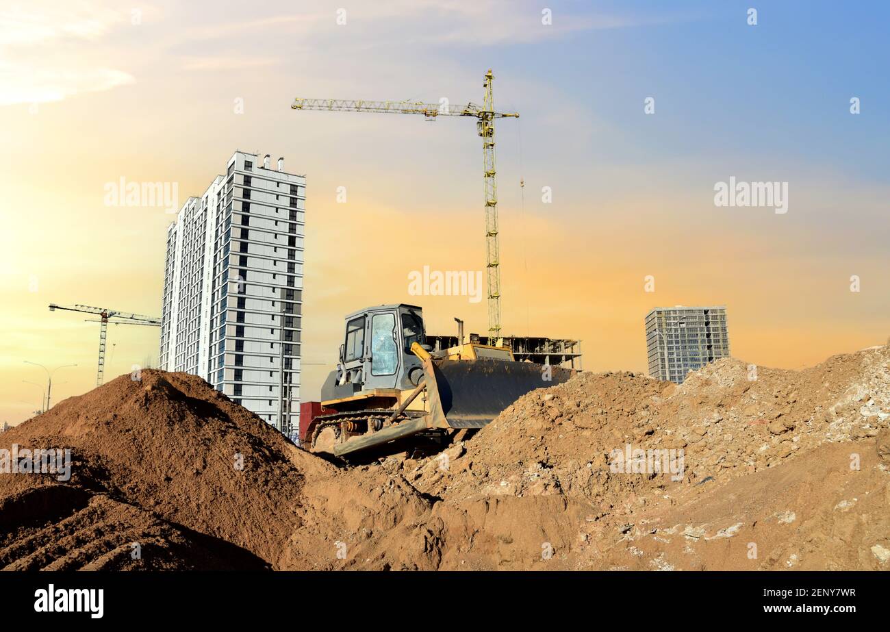 Dozer on earthmoving at construction site on sunset background ...